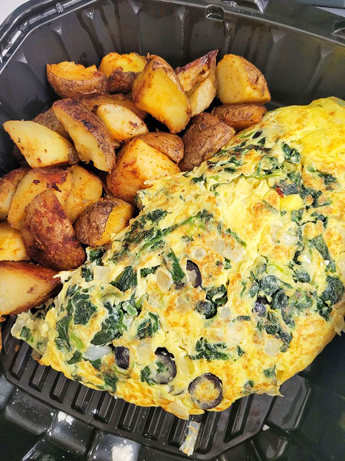 This isn't just an omelet&mdash;it's a vegetable treasure chest wrapped in a golden egg blanket, escorted by potatoes that clearly went to finishing school.