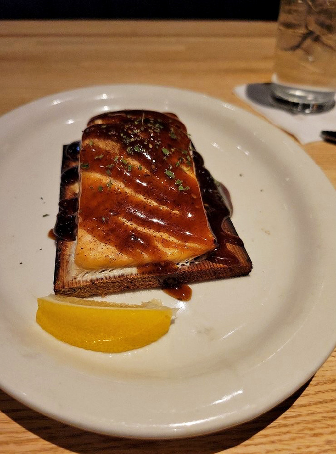 Cedar-planked salmon that's been kissed by flame and glazed to perfection. The lemon wedge isn't garnish&mdash;it's the exclamation point on a delicious sentence.