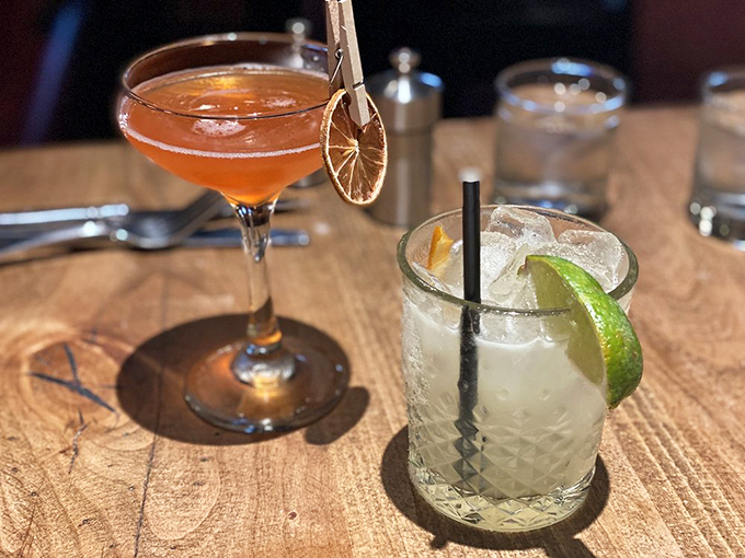 Cocktail artistry at its finest&mdash;a citrusy Manhattan with dried orange garnish alongside a classic margarita that tastes like vacation in a glass.
