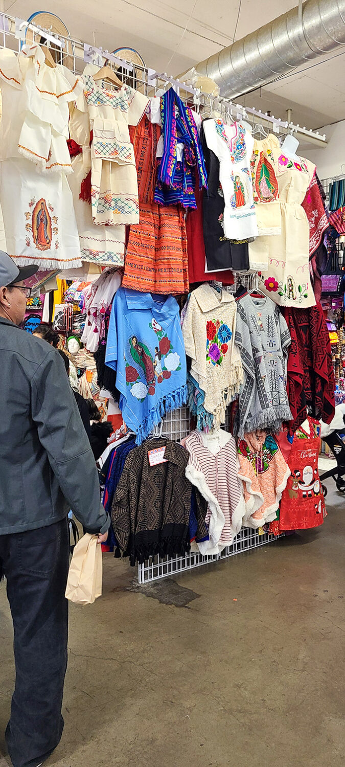 T-shirts tell stories at M&M Marketplace. This wall of graphic tees showcases everything from beer logos to band merch. 