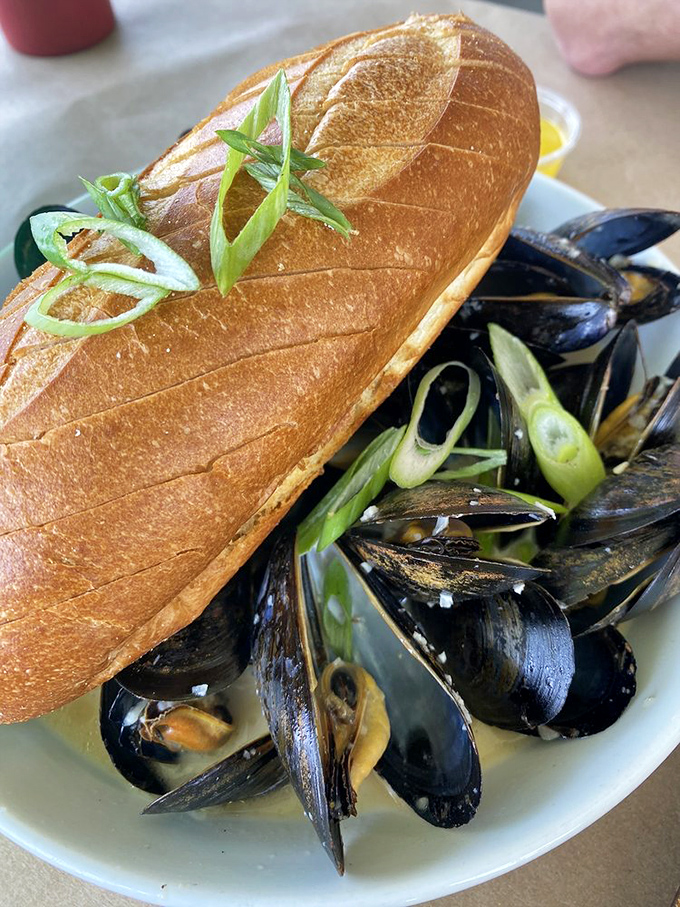 Mussels with a crusty baguette: nature's perfect partnership. Like Batman and Robin, if they were delicious and served in a savory broth.