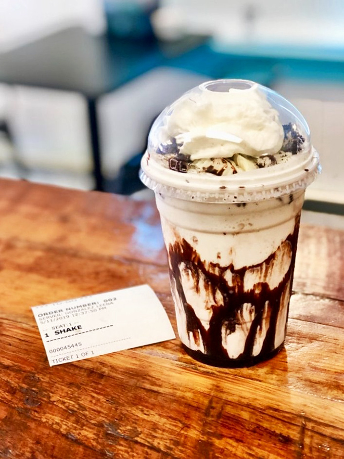 The Oreo milkshake arrives like a dessert skyscraper—chocolate drizzle cascading down the sides like it's auditioning for a food commercial.
