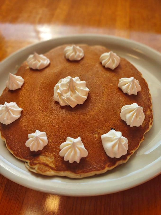 Pancake perfection with whipped cream dollops dancing across the golden surface&mdash;breakfast that doubles as a legitimate reason to get out of bed.