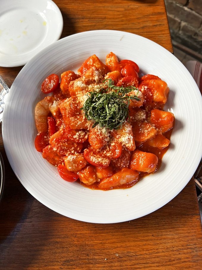 Gnocchi in tomato sauce topped with fresh herbs&mdash;comfort food that whispers rather than shouts, letting quality ingredients tell the story.