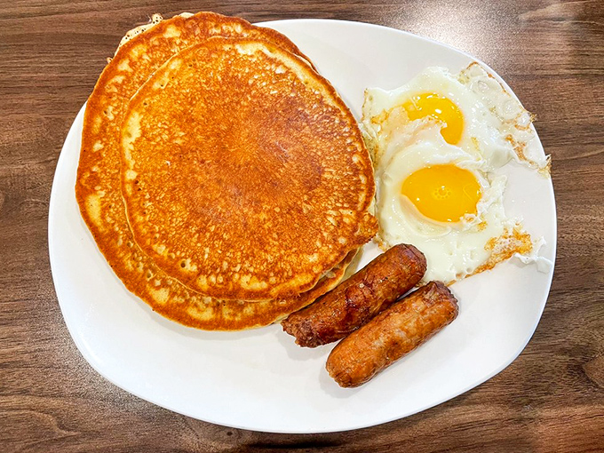 Breakfast of champions: golden pancakes that could double as frisbees, sunny-side eggs, and sausage links that mean business.