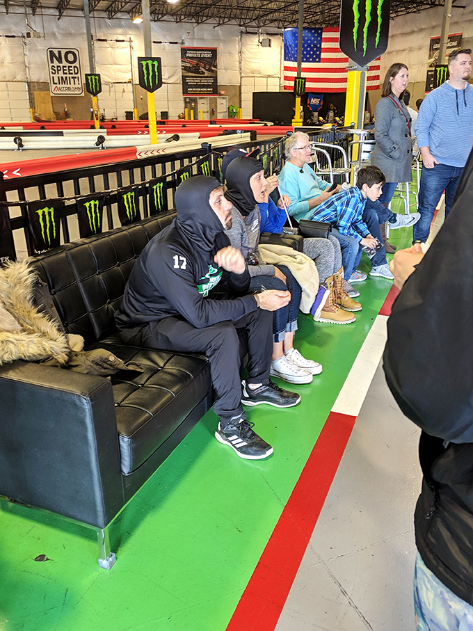 The pit area buzzes with anticipation as drivers prepare for their race. That helmet hair afterward? A small price to pay for glory. 