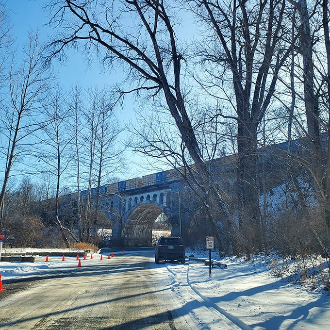 Winter's stark beauty frames the bridge against a snow-dusted landscape, when the cold air seems to amplify every unexplained sound beneath the arches.