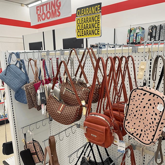 Handbag heaven under the fitting room sign. The "clearance" banner above might as well read "fashion emergency solved."
