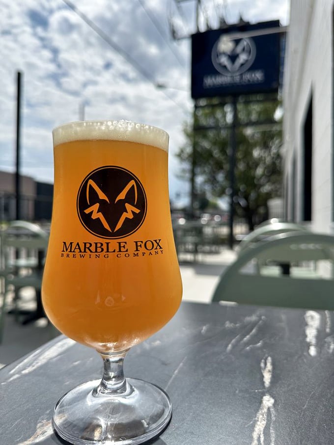 Sunshine captured in a glass! This golden brew gleams against Nashville's blue sky, promising refreshment that's worth every sip.