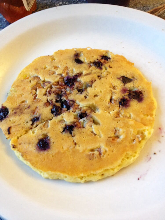 Blueberry pancakes that don't just have berries, they celebrate them &ndash; each purple burst a tiny flavor explosion waiting to meet maple syrup.