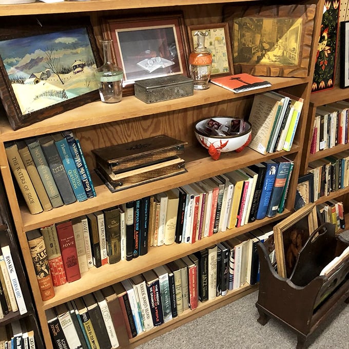 Books stacked with the precision of a literary Jenga tower. That vintage winter landscape painting above would pair perfectly with a fireside reading nook.
