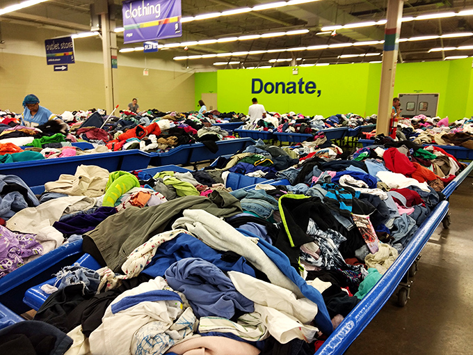 "Donate" glows in neon green against a sea of garments. One person's spring cleaning becomes another's fashion revolution.