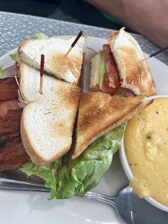 When a sandwich requires structural support from toothpicks, you know you're in for something substantial. Club sandwiches: the skyscrapers of lunch architecture.