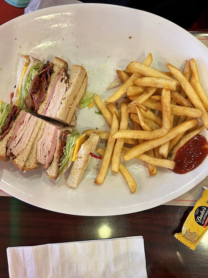 The architectural marvel known as the club sandwich&mdash;where each perfectly toasted layer tells its own delicious story. The fries are just showing off.