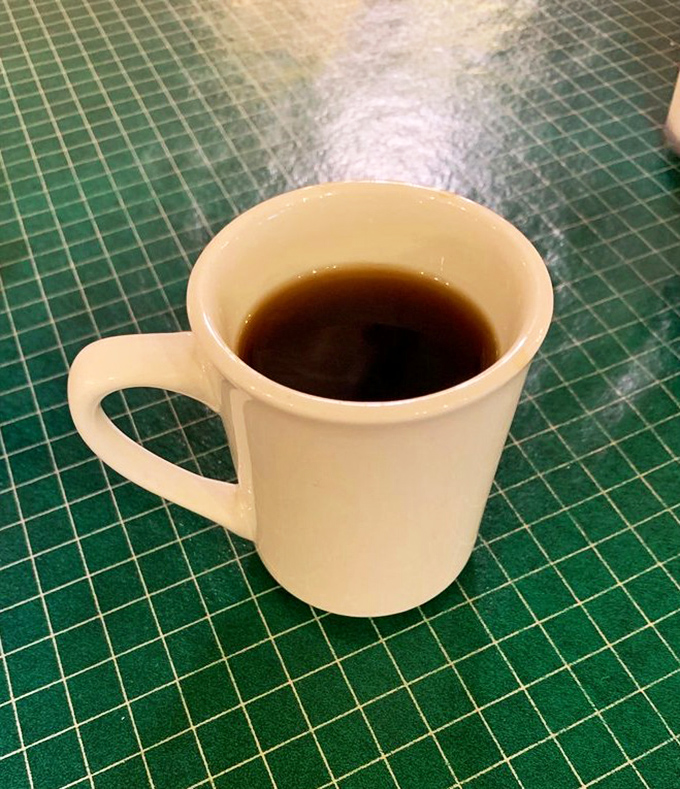 Simple pleasures: Hot coffee in a no-nonsense mug on a green tablecloth. Sometimes the perfect breakfast companion doesn't need fancy attire.