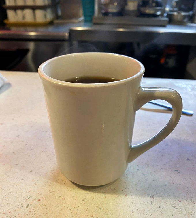 That simple white mug holds liquid optimism—diner coffee that's been waking up Columbia since before Instagram made food photography a thing.