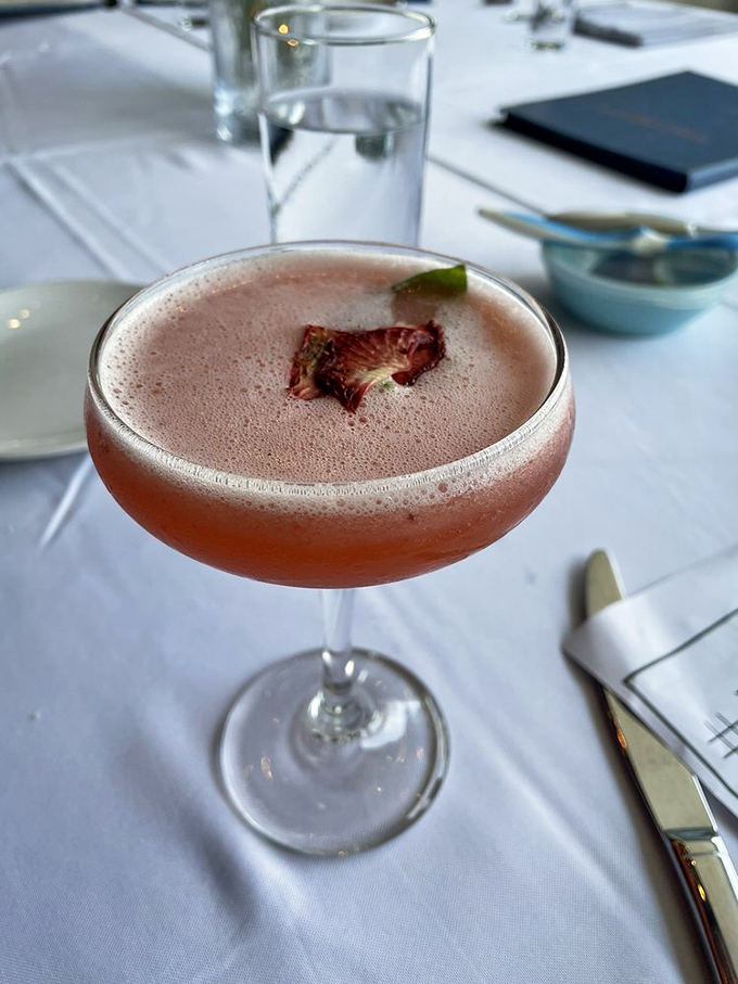 A cocktail that's dressed better than most wedding guests. That delicate dried flower garnish is the tiny hat that makes the whole ensemble sing.