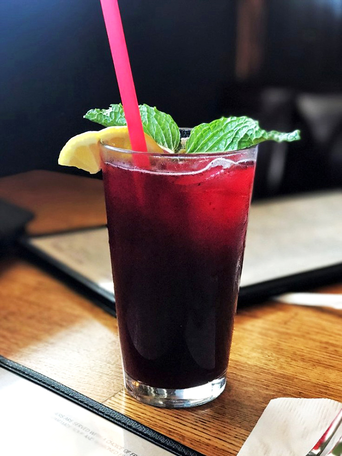 This isn't just a beverage&mdash;it's a ruby-hued vacation in a glass. That mint leaf isn't garnish; it's the little green flag planted at the summit of refreshment.