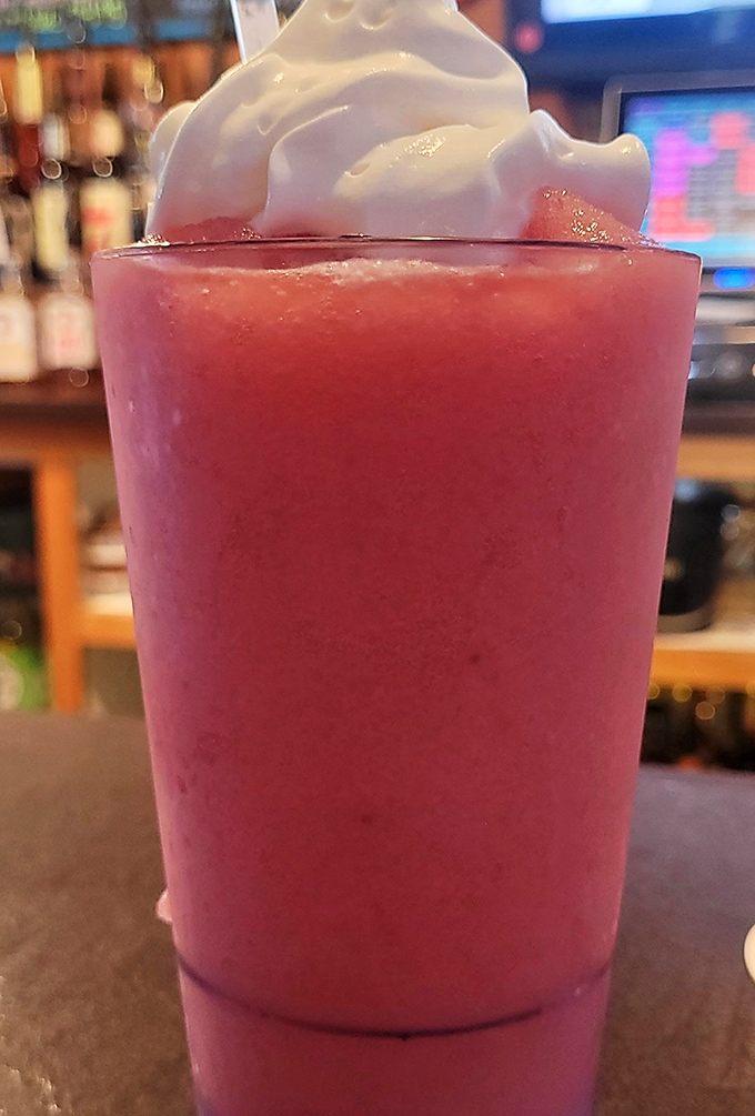 This vibrant frozen concoction isn't just a drink—it's summer in a glass, complete with a whipped cream cloud floating on top.