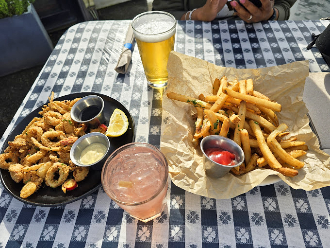 Calamari, fries, and cold drinks&mdash;the holy trinity of waterfront dining. Notice how even the seagulls are eyeing your plate with professional envy.