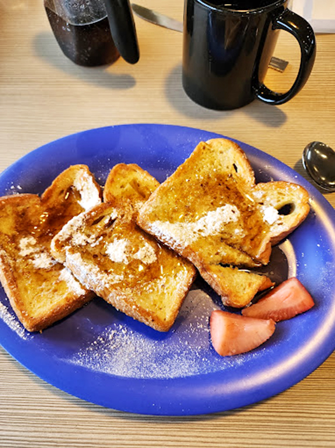 French toast that's been through finishing school &ndash; powdered sugar, a touch of strawberry, and enough butter to make a cardiologist wince gloriously.