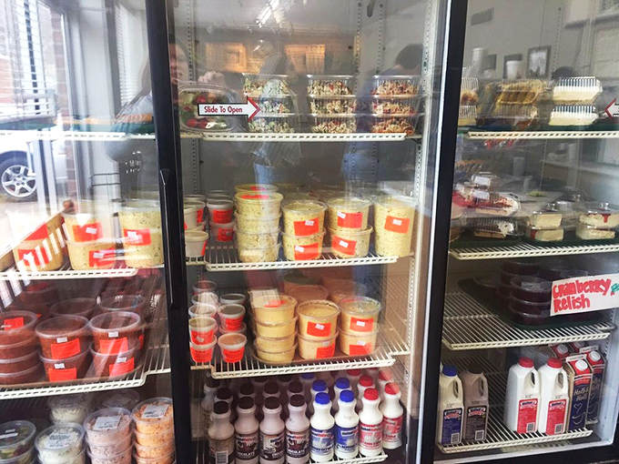 The refrigerator case holds containers of sides waiting to complement the star of the show&mdash;like supporting actors who know their crucial role in the meal.