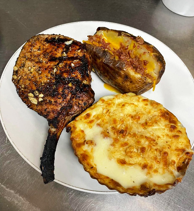 That pork chop is prepared with the respect it deserves, alongside a loaded baked potato and mac and cheese that refuse to be upstaged.