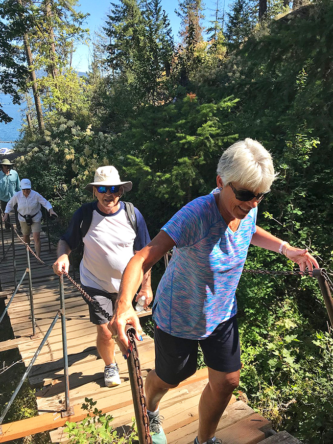 Fellow explorers navigating one of the trail's more adventurous sections. The handrail says "family-friendly," but the view screams "epic wilderness experience."