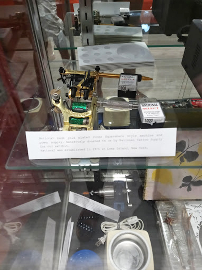 Gold-plated history &ndash; this gleaming vintage tattoo machine sits like jewelry in its display case, a testament to when functional tools were also objects of beauty.