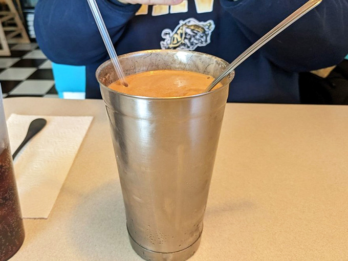 The milkshake comes dressed in old-school silver, thick enough to require serious straw technique. Worth every calorie and brain freeze.