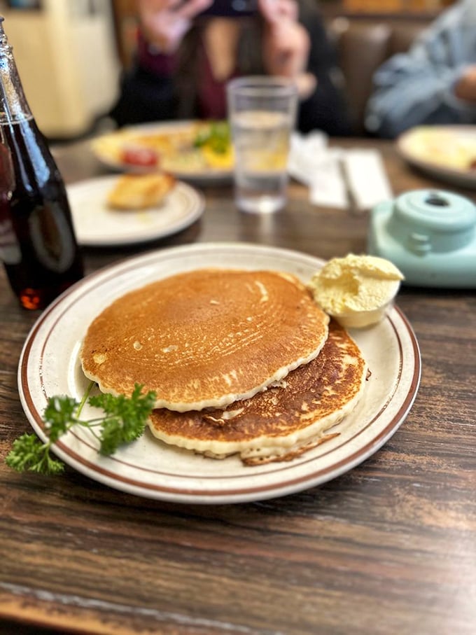 Pancakes so perfectly golden they belong in Fort Knox. That pat of butter melting on top is performing a slow dance of deliciousness.