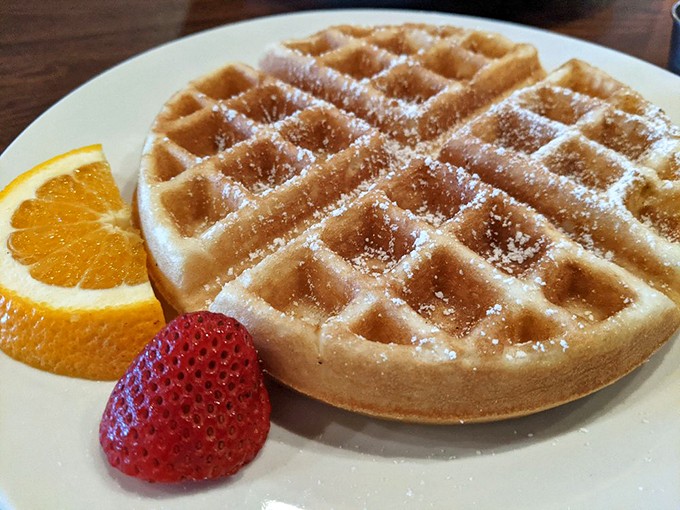 Simple perfection: a golden waffle with fresh berries and a citrus smile. Sometimes the classics don't need reinventing&mdash;just perfecting.