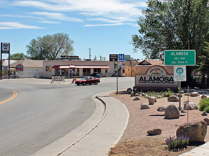 Alamosa welcomes visitors with its distinctive sign, promising small-town hospitality with a side of "yes, your retirement savings will actually last here."
