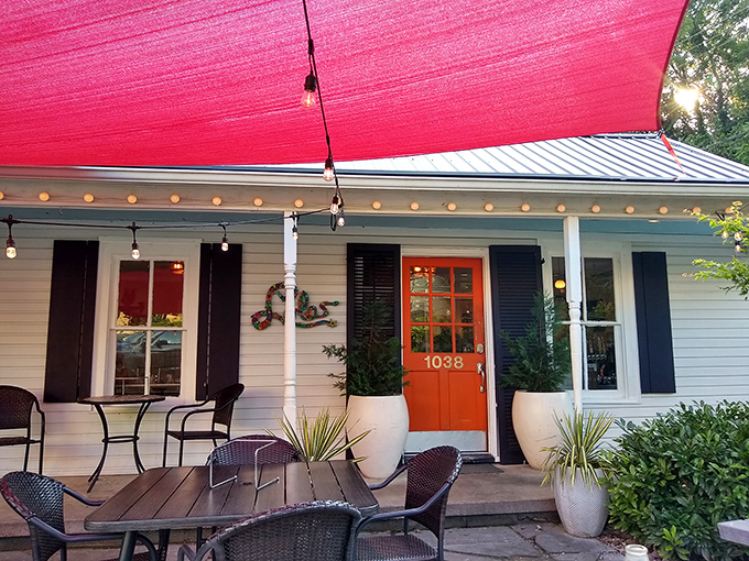 That inviting porch and vibrant orange door – the gateway to Charleston's most delightful pizza experience.