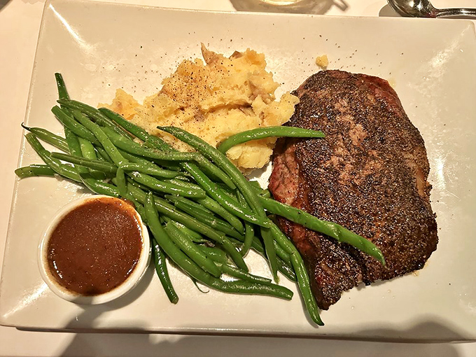 This ribeye isn't just a steak &ndash; it's a carnivore's sonnet with a perfectly charred exterior and a side of green bean poetry.