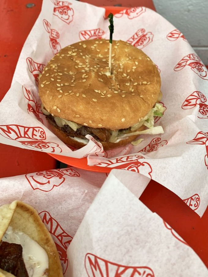 Some burgers require a strategic approach. This cheese-draped behemoth demands both hands, several napkins, and absolutely zero shame.