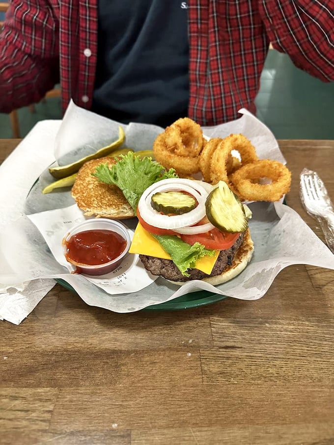Simplicity perfected: a cheese-draped patty with golden mozzarella sticks standing guard. No fancy tricks needed when the basics are this good.