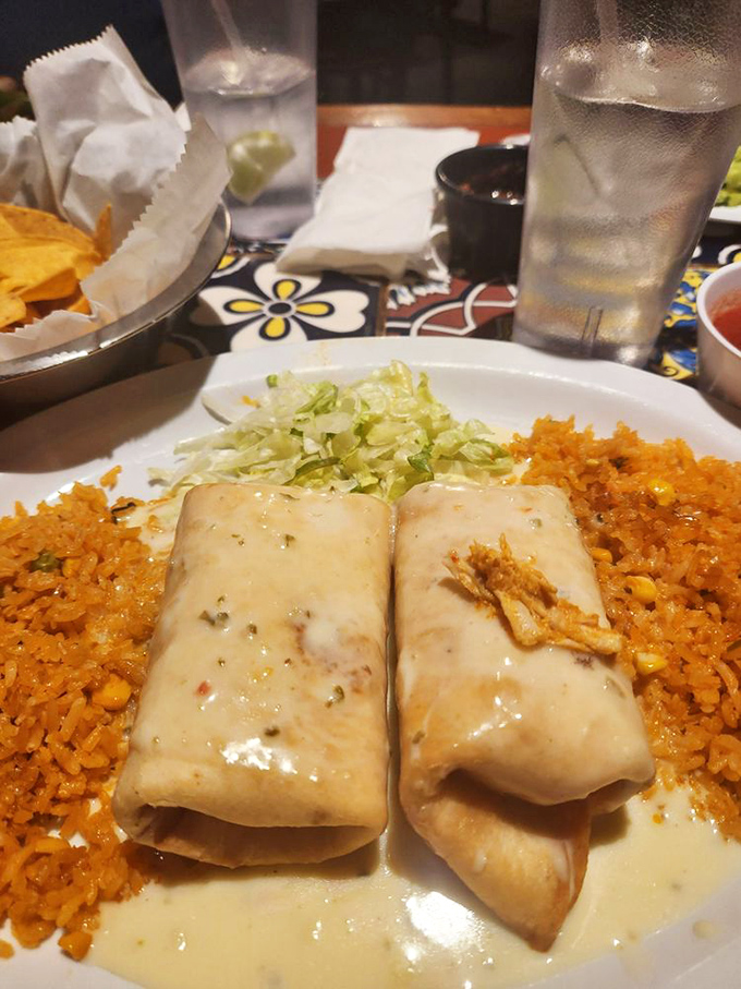 These chimichangas look like they've been tucked in for the night under a blanket of sauce and cheese, dreaming sweet dreams of being devoured.
