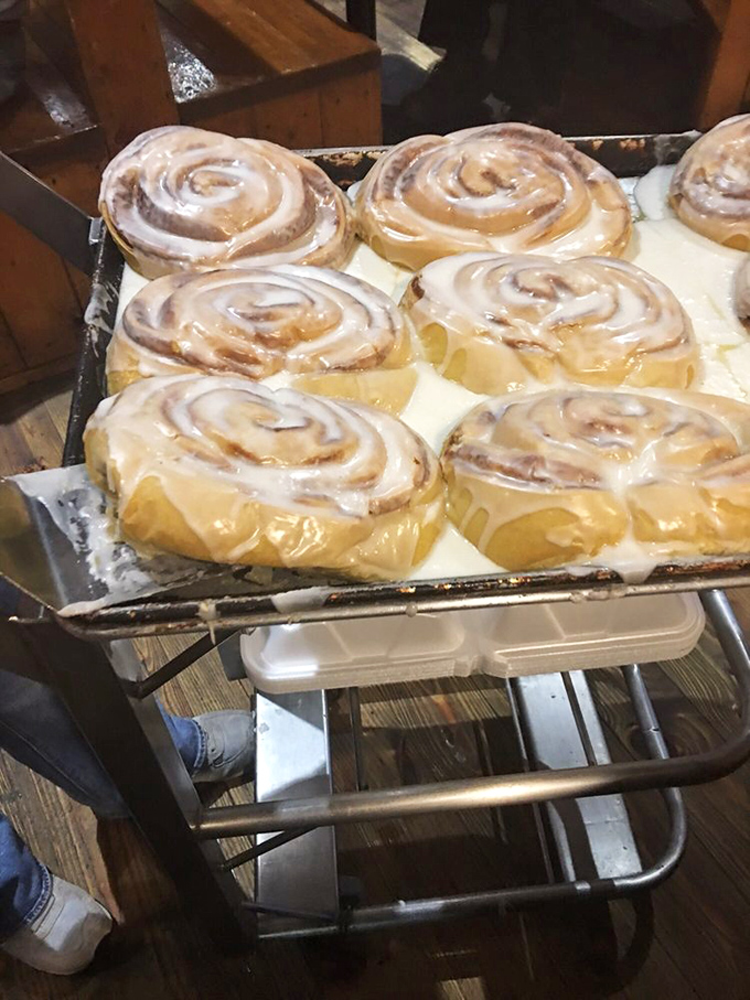 Cinnamon rolls the size of small throw pillows, glistening with icing that's melting just enough to make you contemplate licking the tray when no one's looking.