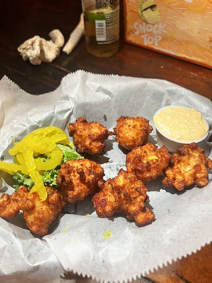 Golden-brown conch fritters that crunch like your first step on beach sand. The banana pepper garnish adds just enough zing to wake up your taste buds.