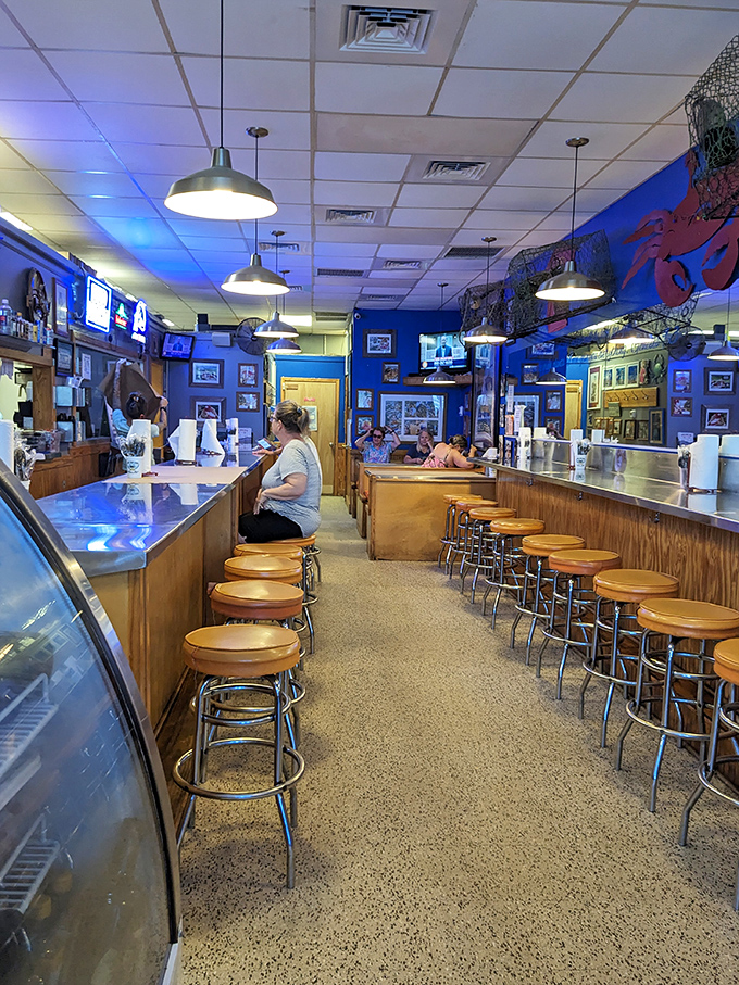 Blue walls and wooden barstools create the perfect casual backdrop for serious seafood consumption. No white tablecloths needed for this authentic experience.