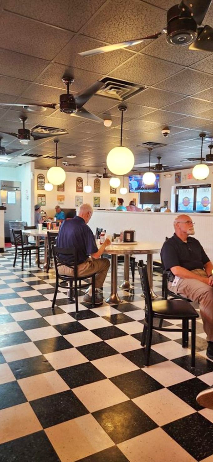 The checkered floor sets the stage for culinary magic, while globe pendant lights cast a warm glow over satisfied diners.