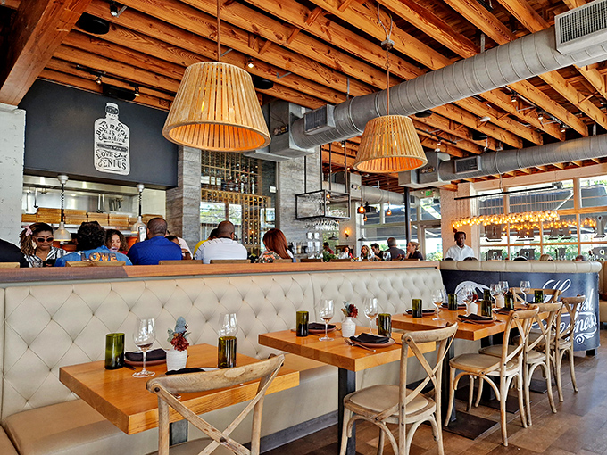 Cream banquettes, wooden tables, and wicker-backed chairs create the perfect setting for Southern indulgence. Like dining in a modern farmhouse that got a design degree.