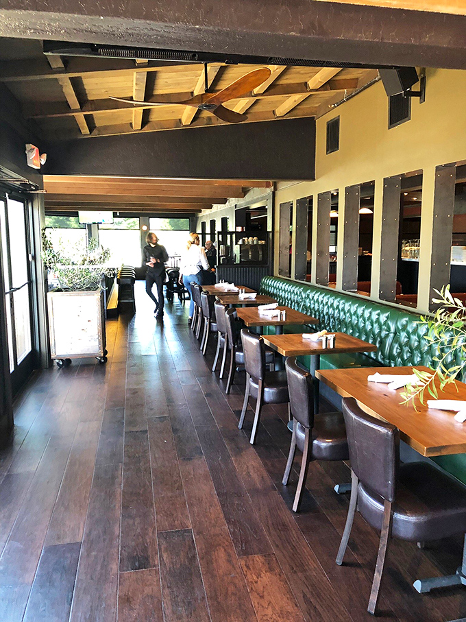 The dining area's emerald green banquettes and rich wooden tables create the perfect backdrop for lingering conversations and memorable meals.