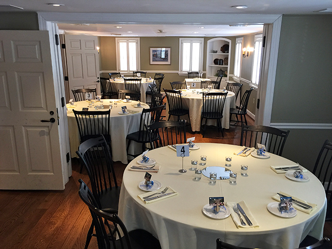 The formal dining room balances elegance with approachability, where white tablecloths meet Windsor chairs in a space that whispers "special occasion" without shouting it.