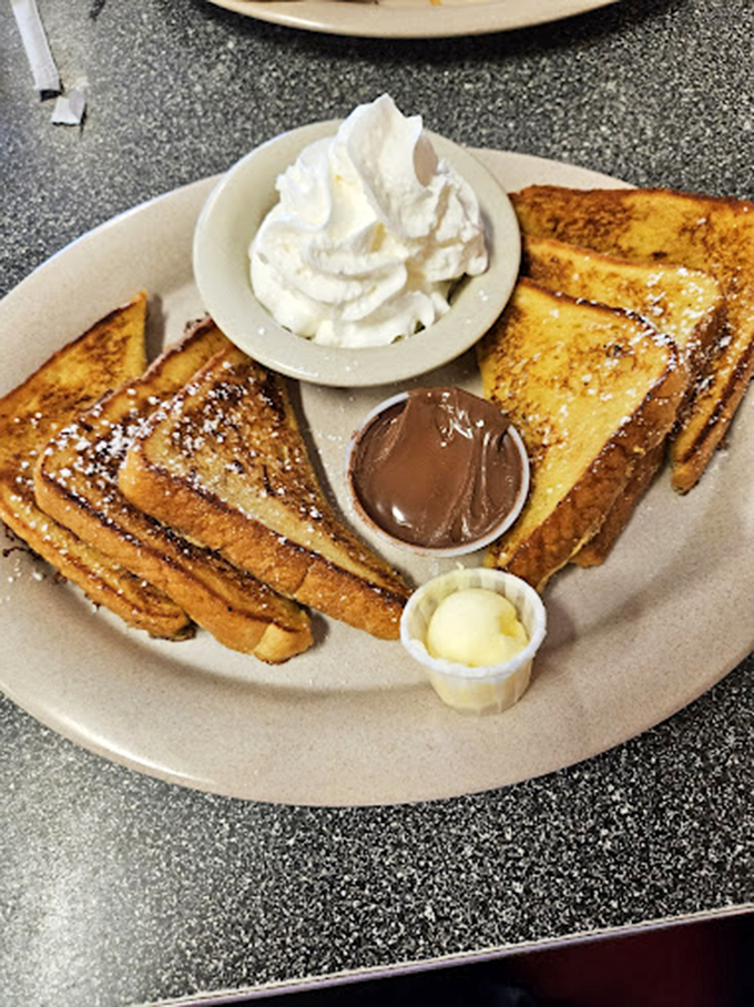 French toast that's been soaking up cinnamon-vanilla custard before hitting the griddle. Add Nutella and whipped cream because... why not?