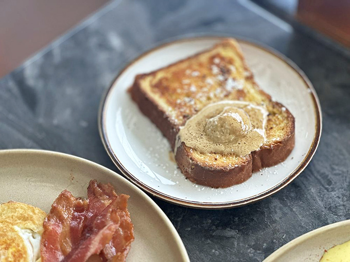 French toast so perfectly golden it belongs in Fort Knox, with a dollop of butter melting like a summer sunset.