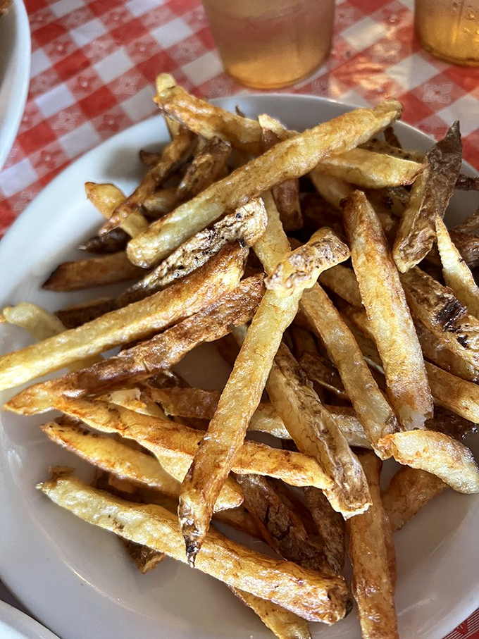 Hand-cut fries with that perfect golden hue, waiting to be dunked in ketchup or secretly smuggled into your napkin for the drive home.