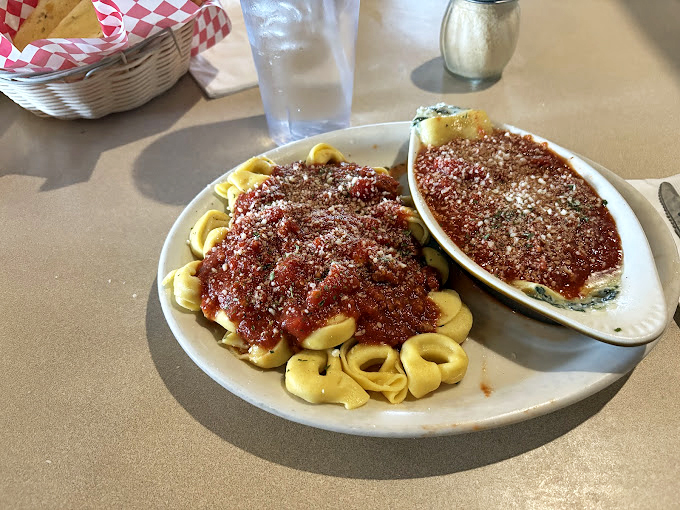 Two plates, one decision: tortellini and what appears to be lasagna, both bathed in that magnificent red sauce. Why choose when you can have both?