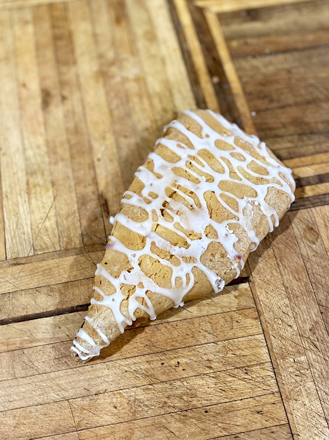 A pastry scone drizzled with sweet icing. Breakfast? Dessert? The lines blur deliciously at this bakery paradise.